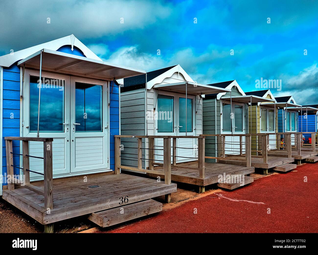 Colourful British seaside beach chalets in a row. Typical traditional ...