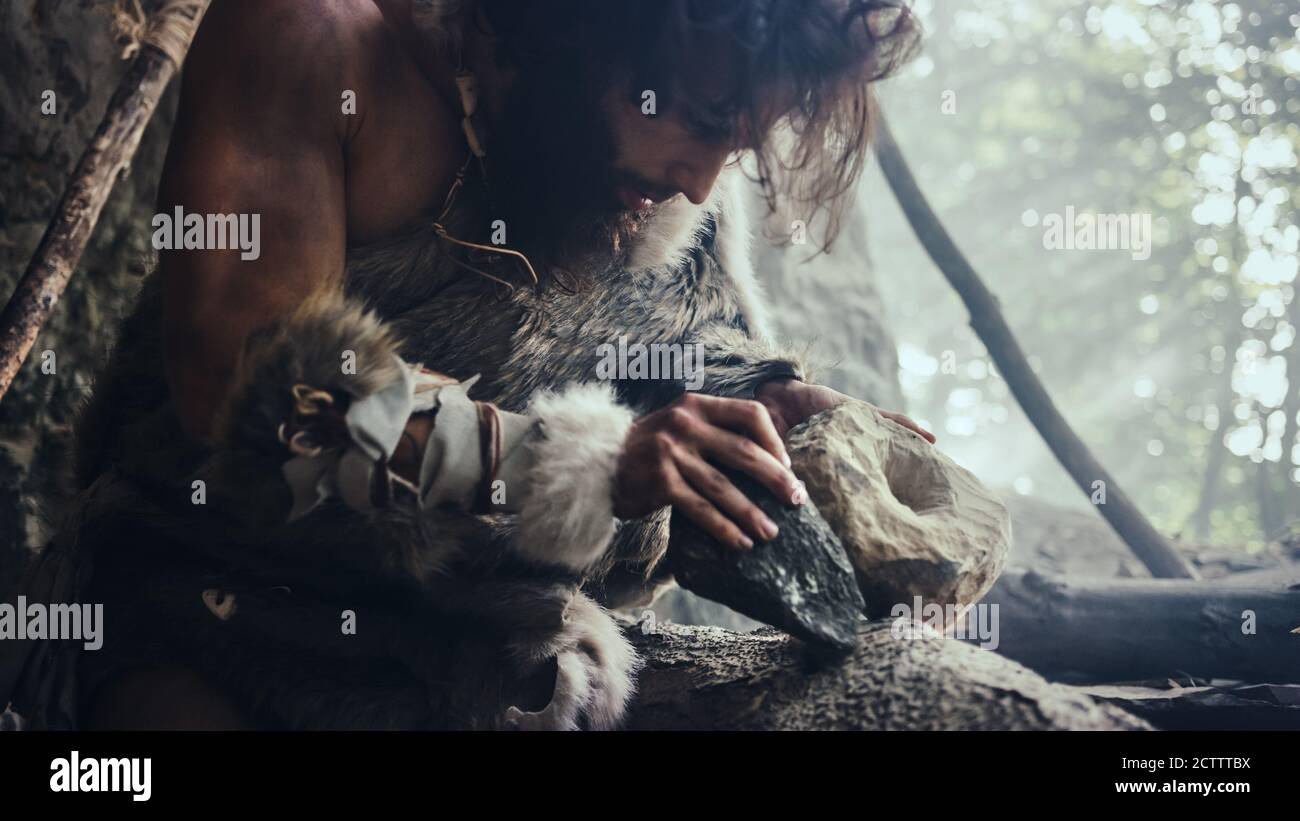 Primeval Caveman Wearing Animal Skin Hits Rock with Sharp Stone and ...