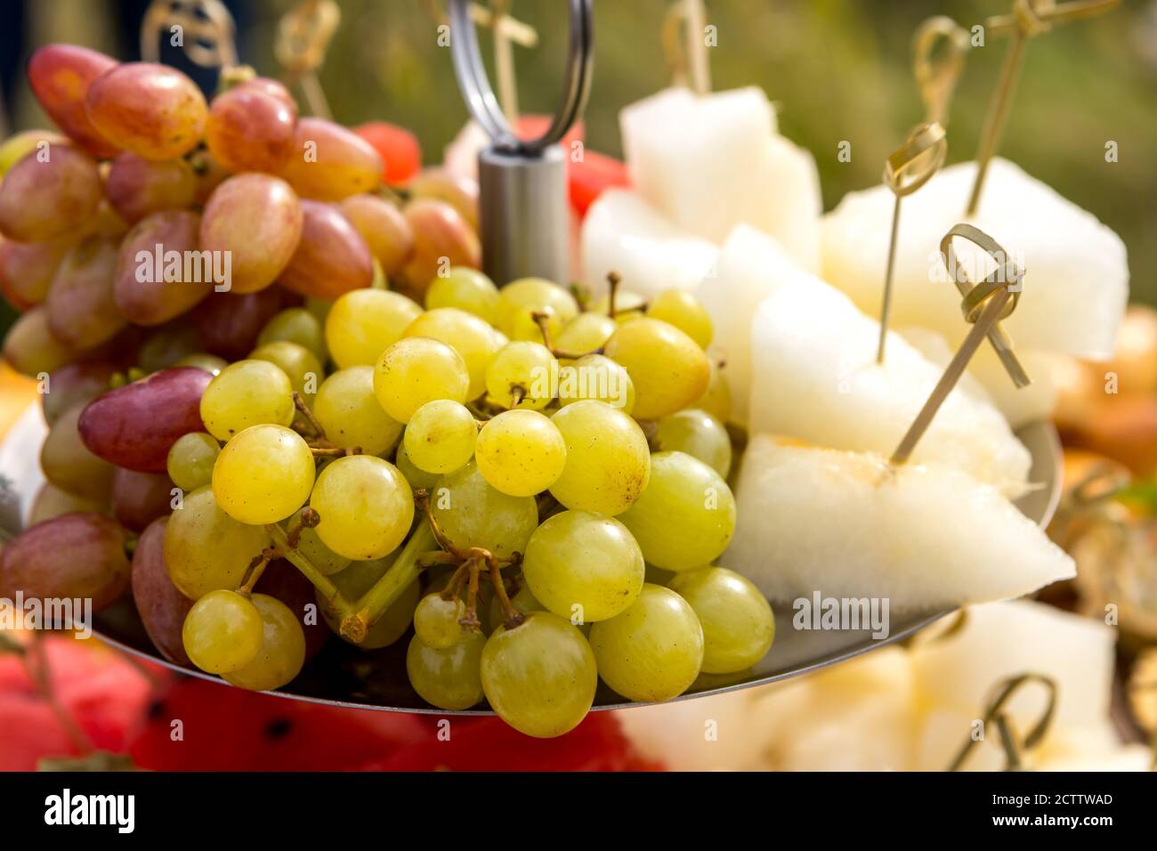Grapes and slices of ripe juicy melon on a platter Stock Photo - Alamy