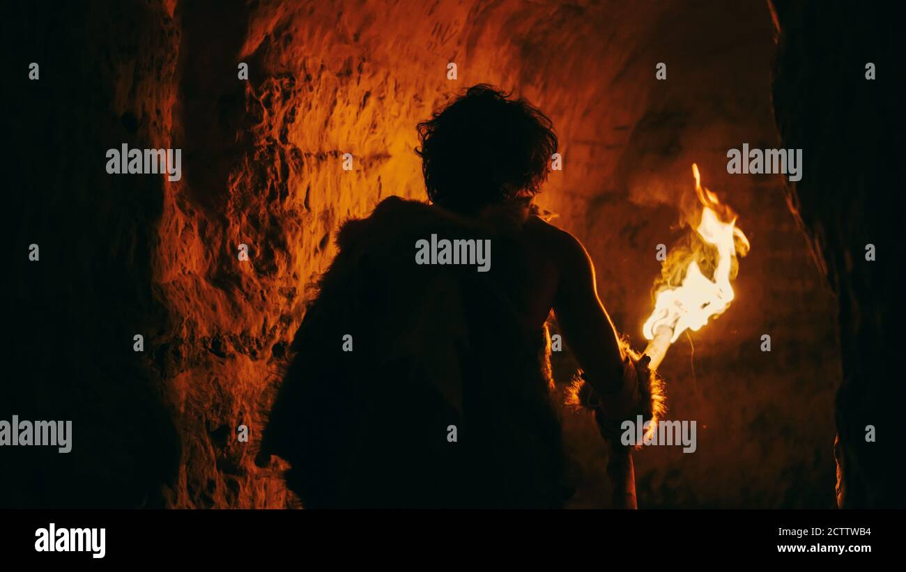 Primeval Caveman Wearing Animal Skin Exploring Cave At Night Holding ...
