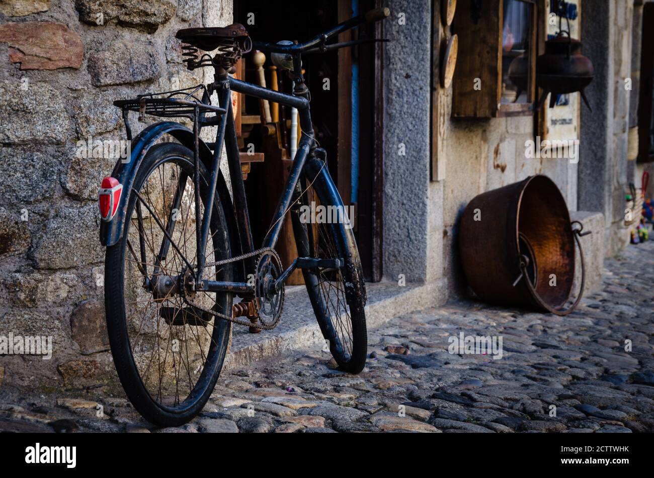 An old bicycle leaning against a facade wall in the medieval village of ...