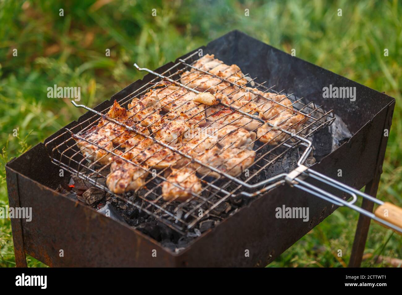 Grilled meat on the grill is cooked on coals in the grill Stock Photo ...