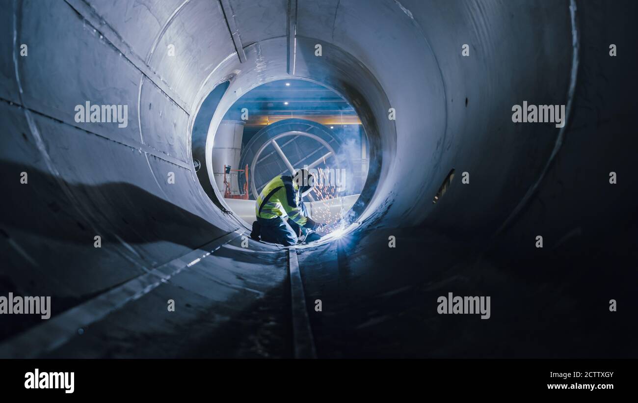 Professional Heavy Industry Welder Working Inside Pipe, Wears Helmet ...