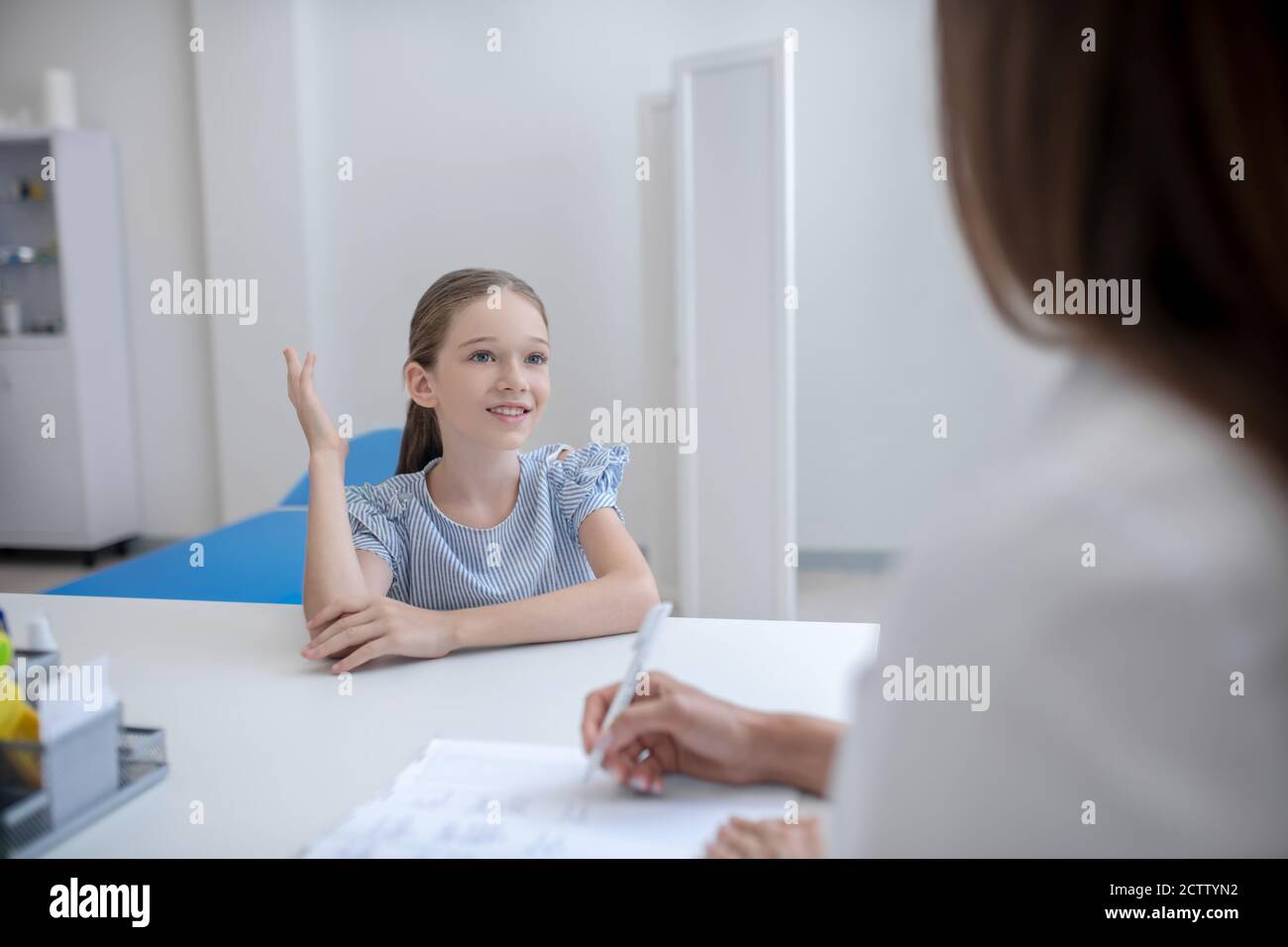Girl having a tutorial in the clinic with a female doctor and raising ...