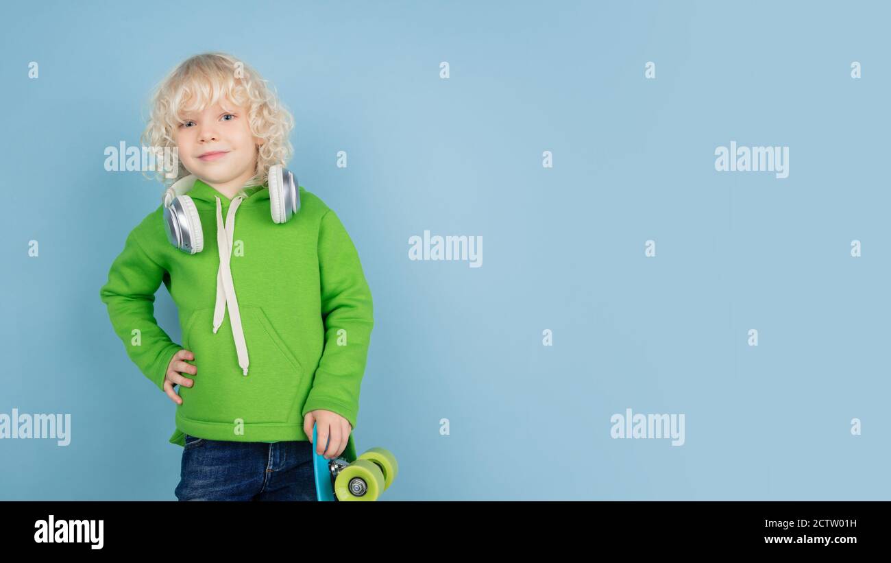 Skater boy. Portrait of beautiful caucasian little boy isolated on blue ...