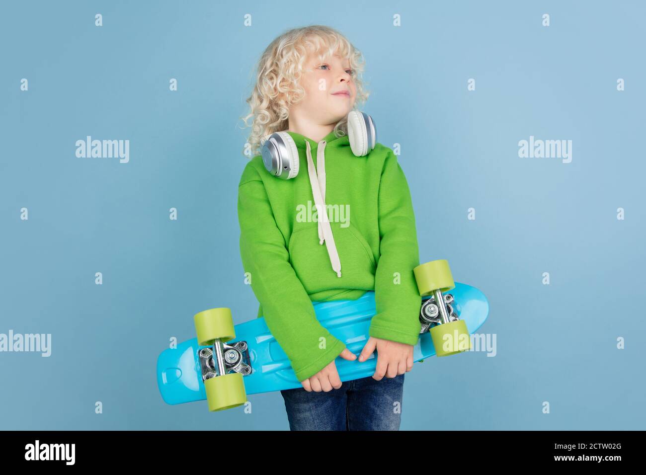 Skater boy. Portrait of beautiful caucasian little boy isolated on blue ...