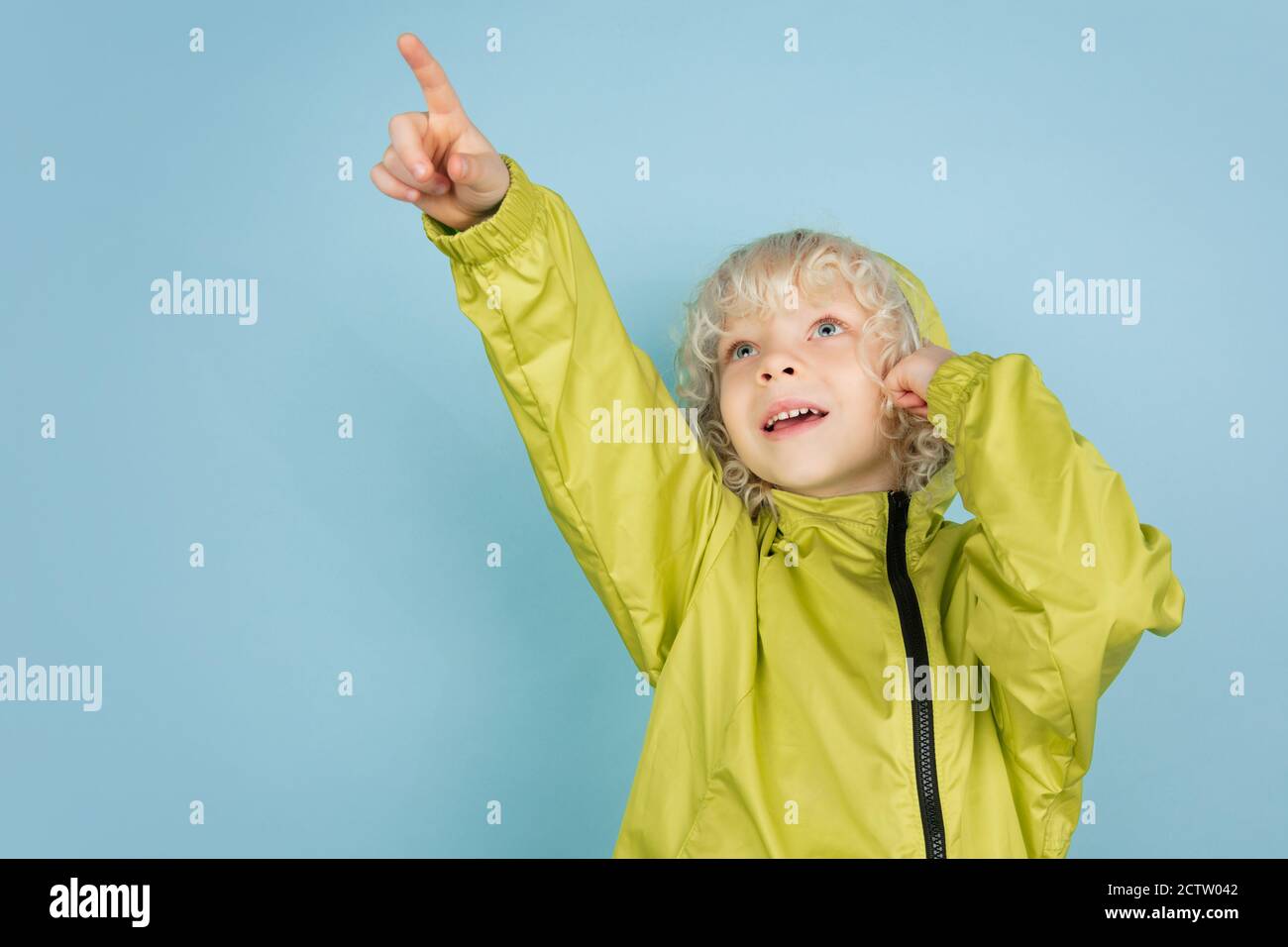 Pointing up. Portrait of beautiful caucasian little boy isolated on ...