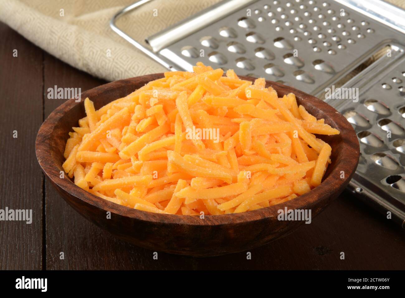 A wooden bowl of shredded sharp cheddar cheese Stock Photo - Alamy