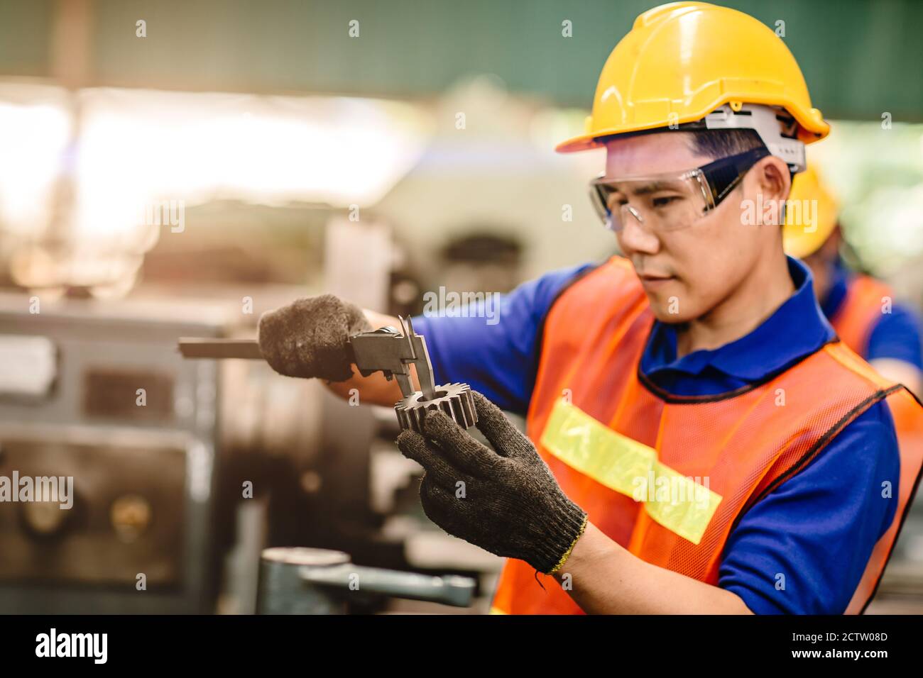 Asian engineer worker using Vernier Caliper to check size for accuracy ...