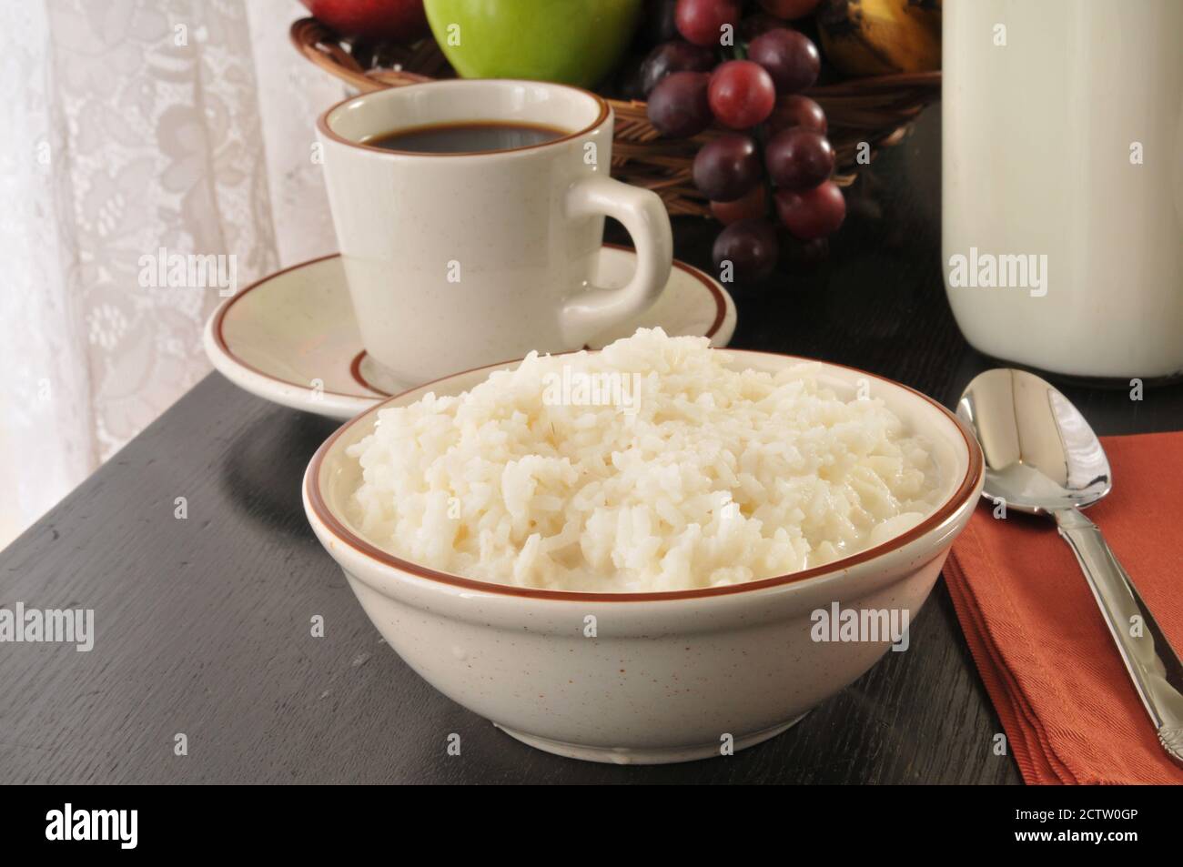 a bowl of steamed white rice with milk for breakfast Stock Photo - Alamy