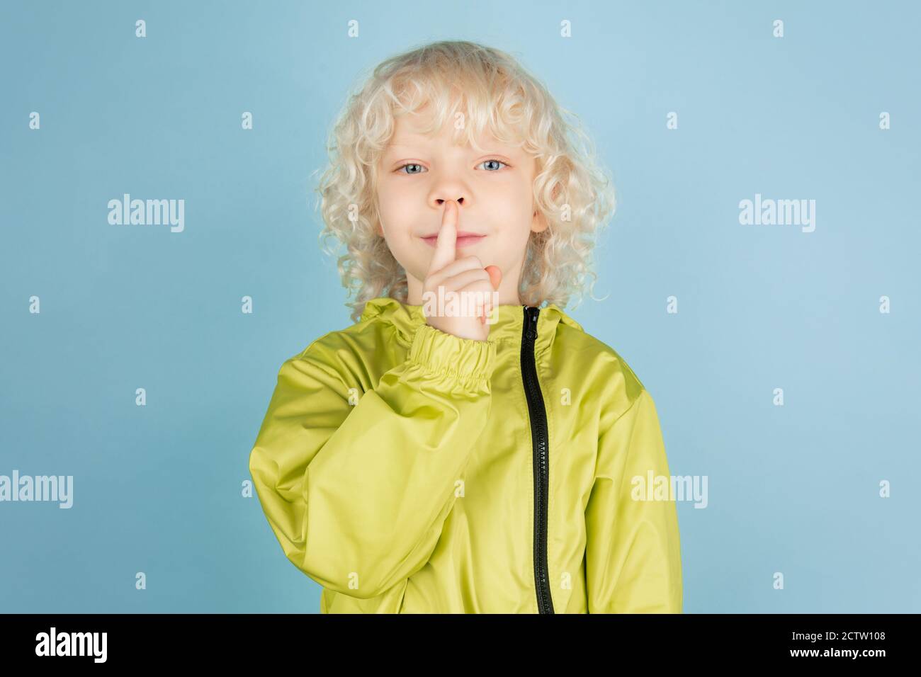 Whispering a secret. Portrait of beautiful caucasian little boy ...