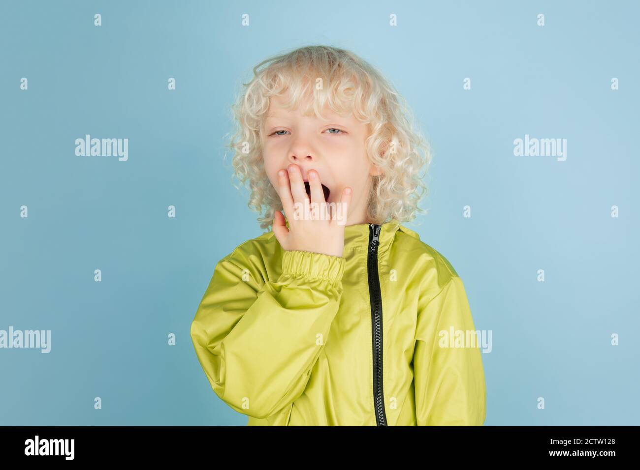 Yawning sleepy. Portrait of beautiful caucasian little boy isolated on ...