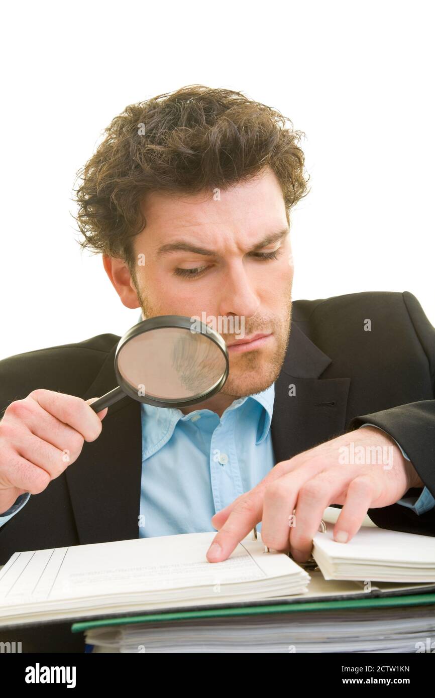 Young man in a suit reading a file with a magnifying glass Stock Photo ...