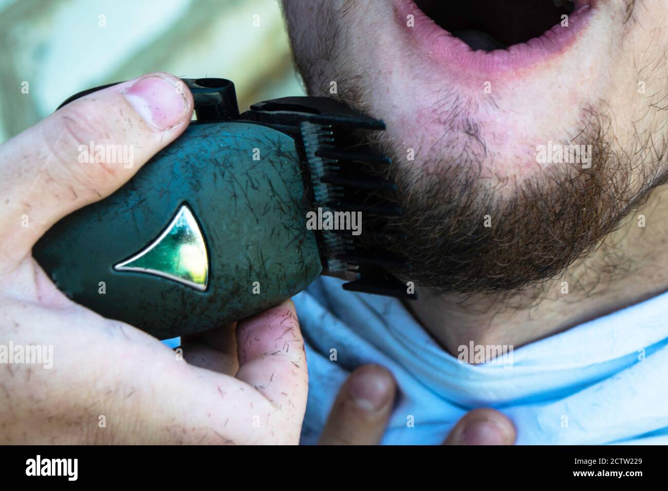 the barber cuts his beard to the guy with a shearing machine Stock ...