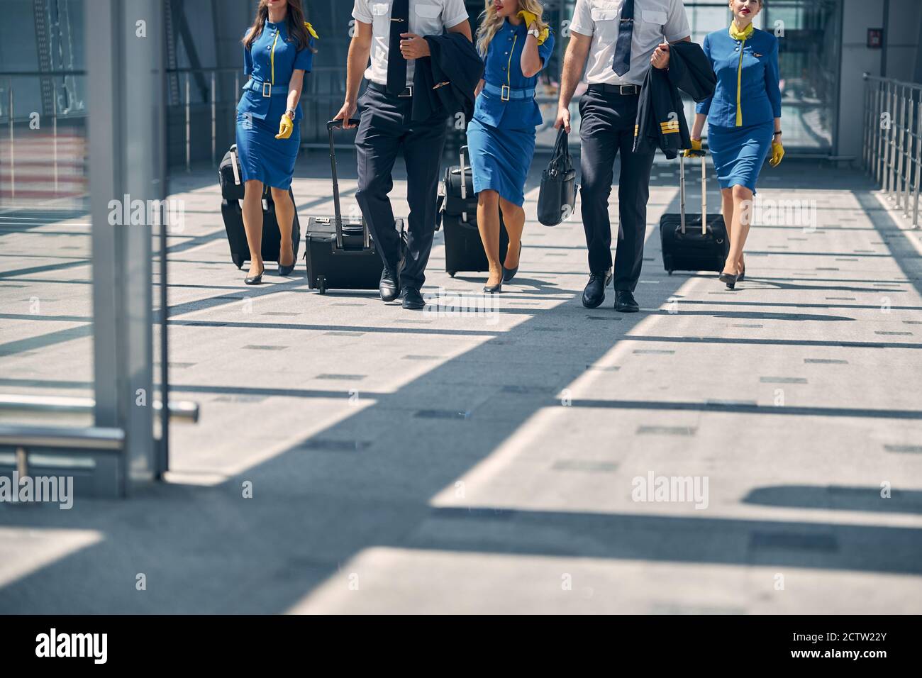 Aircrew members with travel suitcases walking in airport terminal Stock ...
