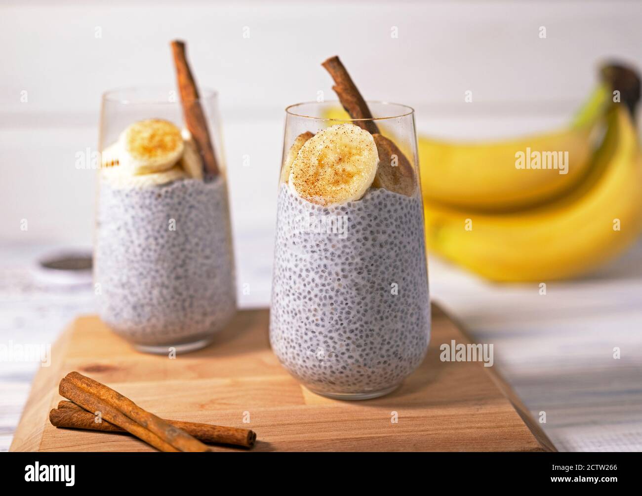 Chia seeds pudding with banana, cinnamon and yougurt on white wooden ...