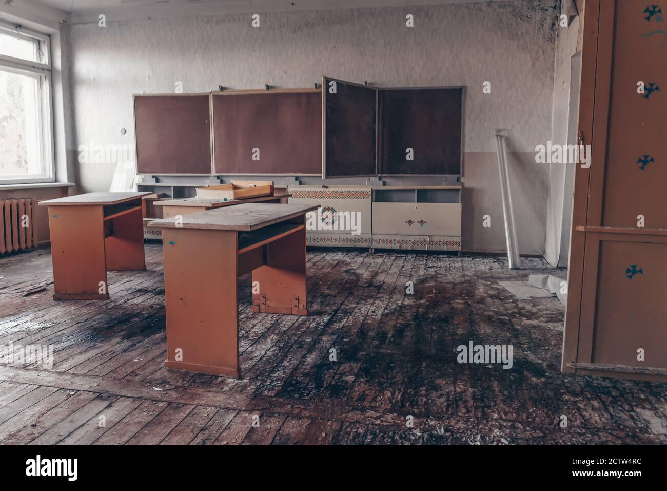 Abandoned classroom with desks and blackboard in an abandoned school ...