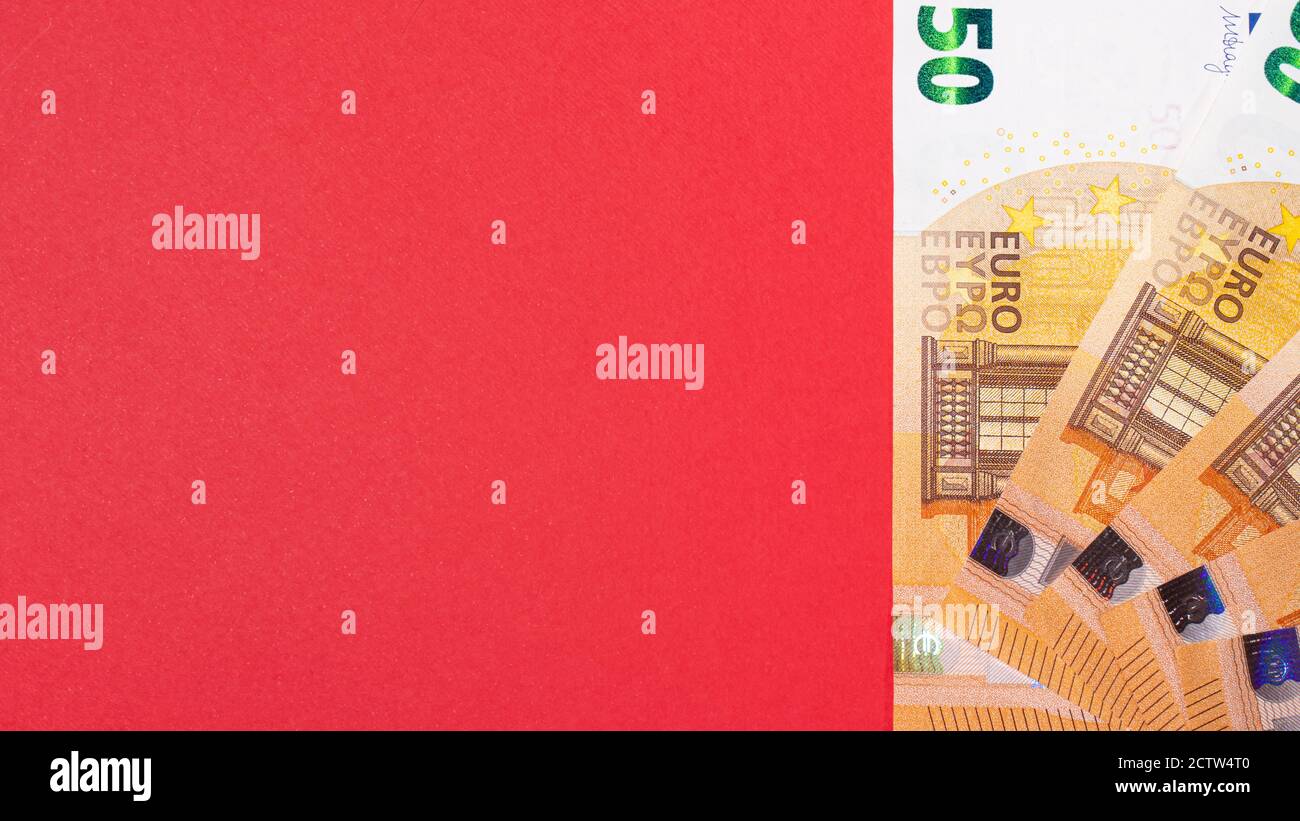 Fragment of the 50 fifty euro banknote on a red background. Close up ...