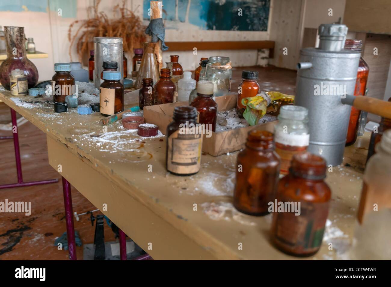 table with old chemical reagents in a classroom in an abandoned school ...