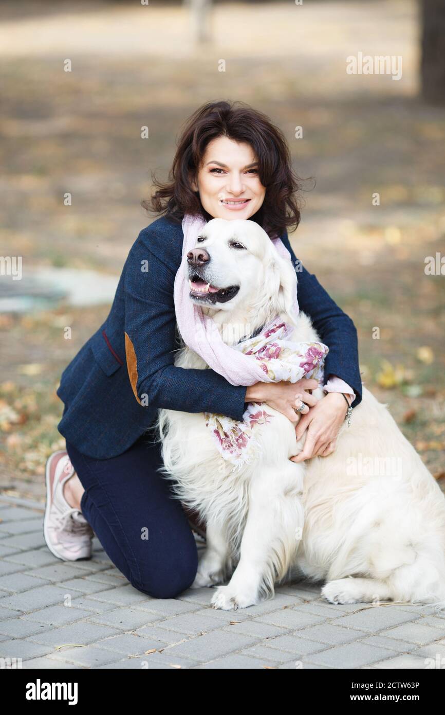 Beauty woman with her dog playing outdoors. Woman walking Labrador ...