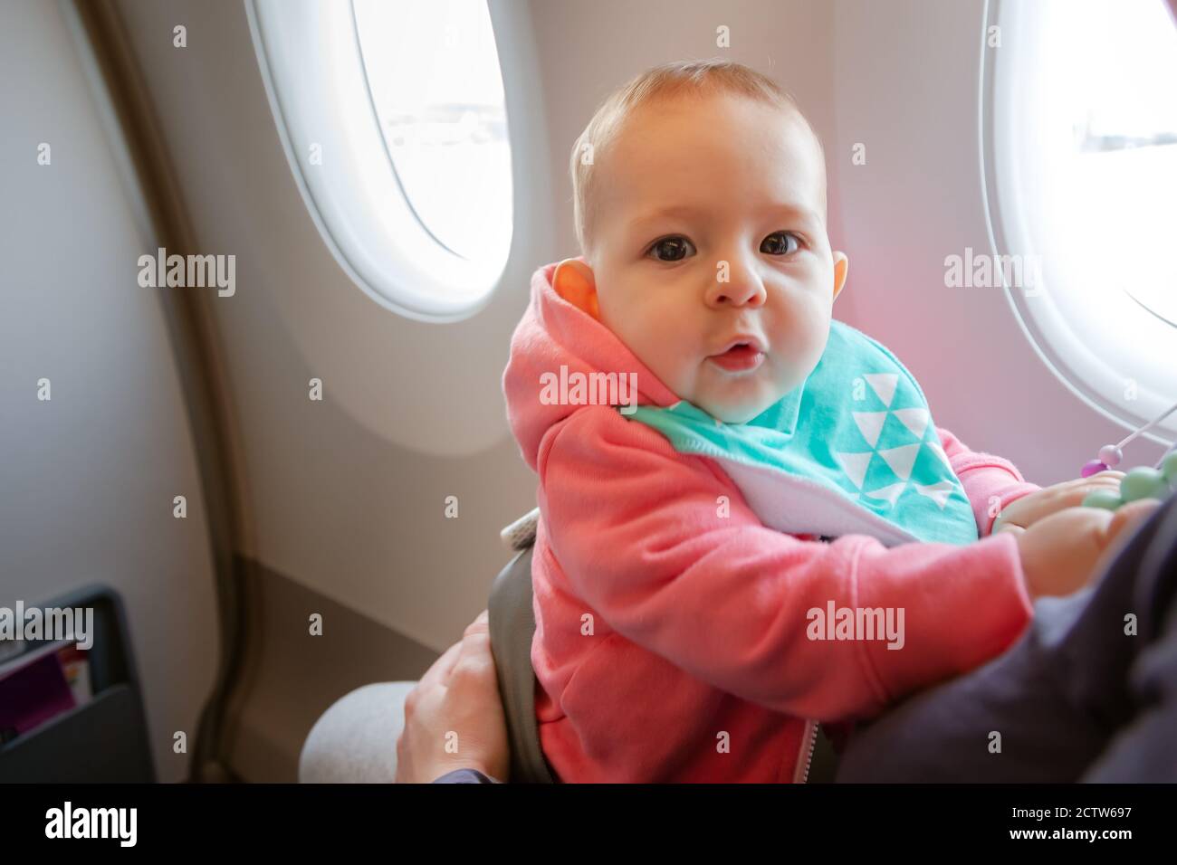 Mother and baby sitting together in airplane. First flight of infant ...