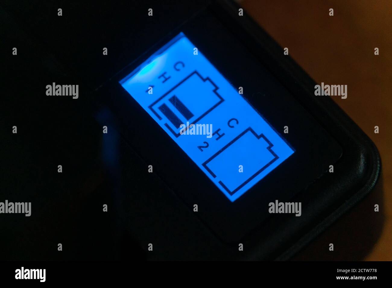 Luminous indicator of the camera battery charger. process of charging ...