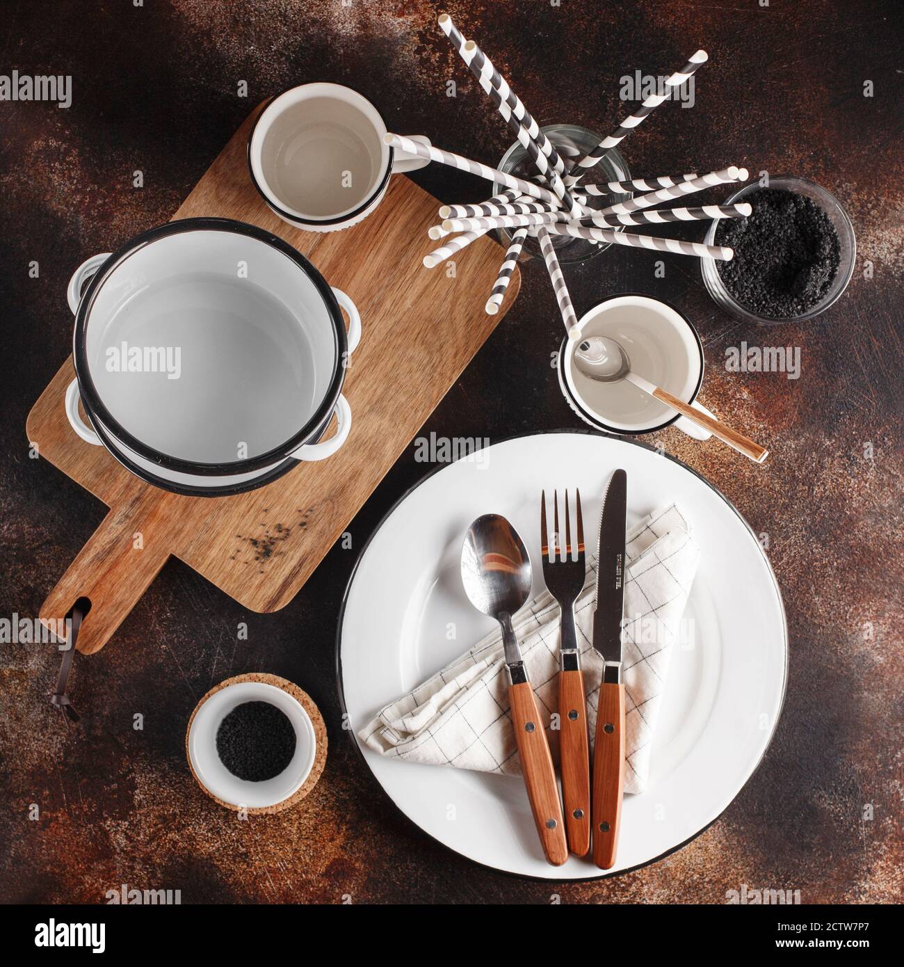 Crockery and cutlery on a dark background with copy space. White metal ...