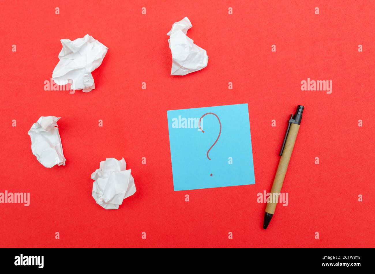 Blue sheet of paper with a question mark, crumpled paper and a pen on a ...