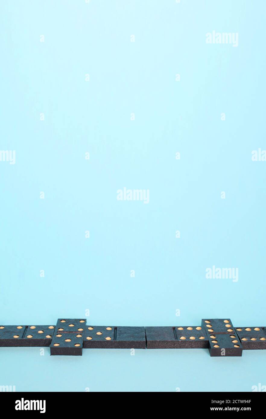 A fragment of a Board game of dominoes on a plain blue background ...