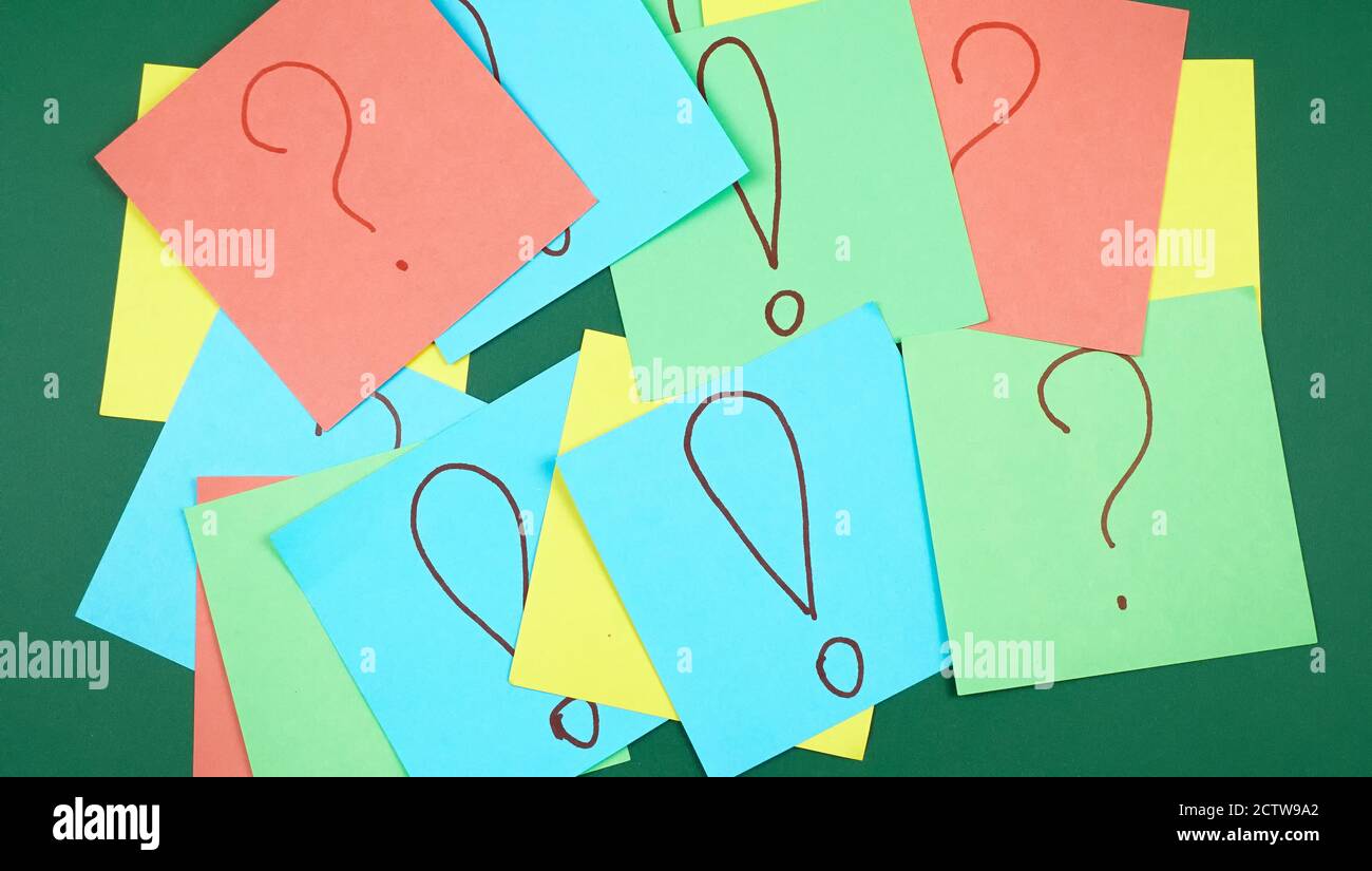 Lots of colorful note sheets with question and exclamation marks on a ...