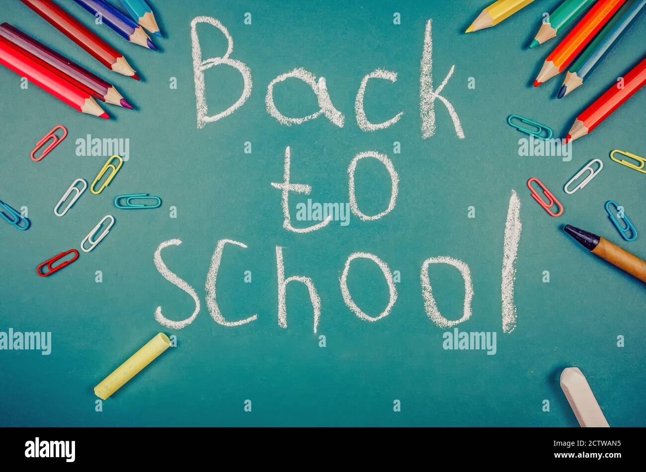 On the blackboard it is written in chalk Back to school, next to paper ...