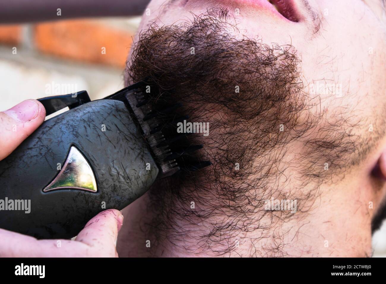 the barber cuts his beard to the guy with a shearing machine Stock ...