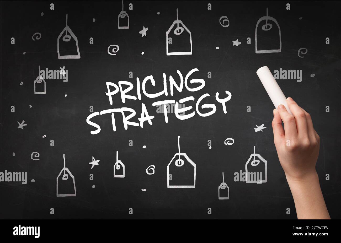 Hand drawing PRICING STRATEGY inscription with white chalk on ...
