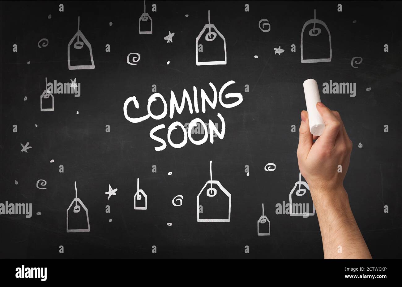 Hand drawing COMING SOON inscription with white chalk on blackboard ...