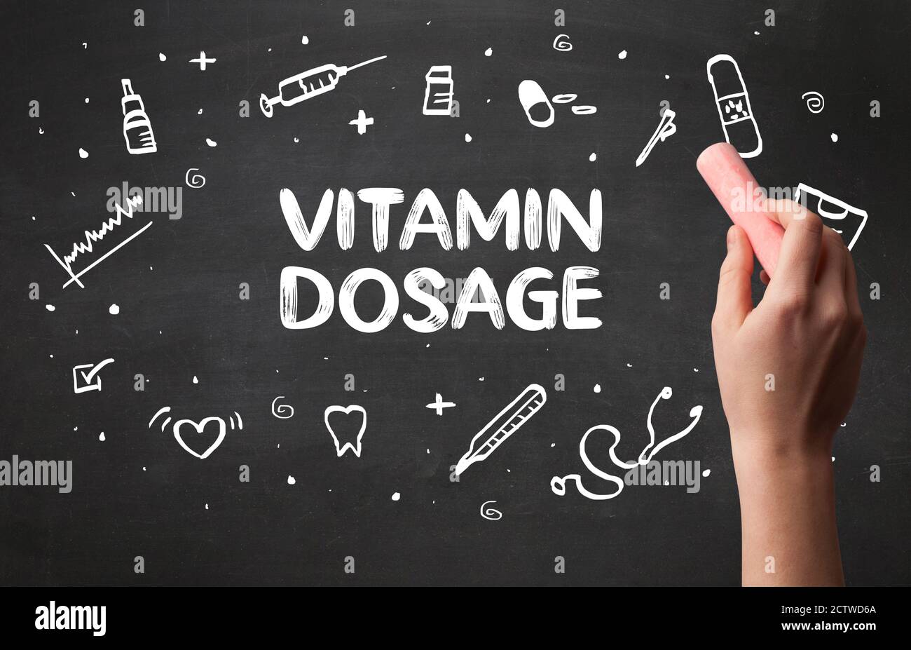 Hand drawing VITAMIN DOSAGE inscription with white chalk on blackboard ...