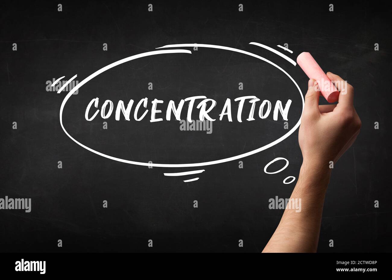 Hand drawing CONCENTRATION inscription with white chalk on blackboard ...