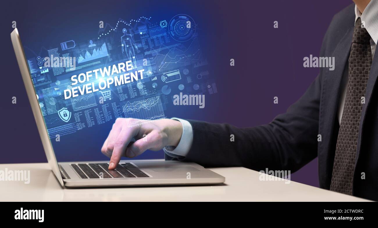 Businessman working on laptop with SOFTWARE DEVELOPMENT inscription ...