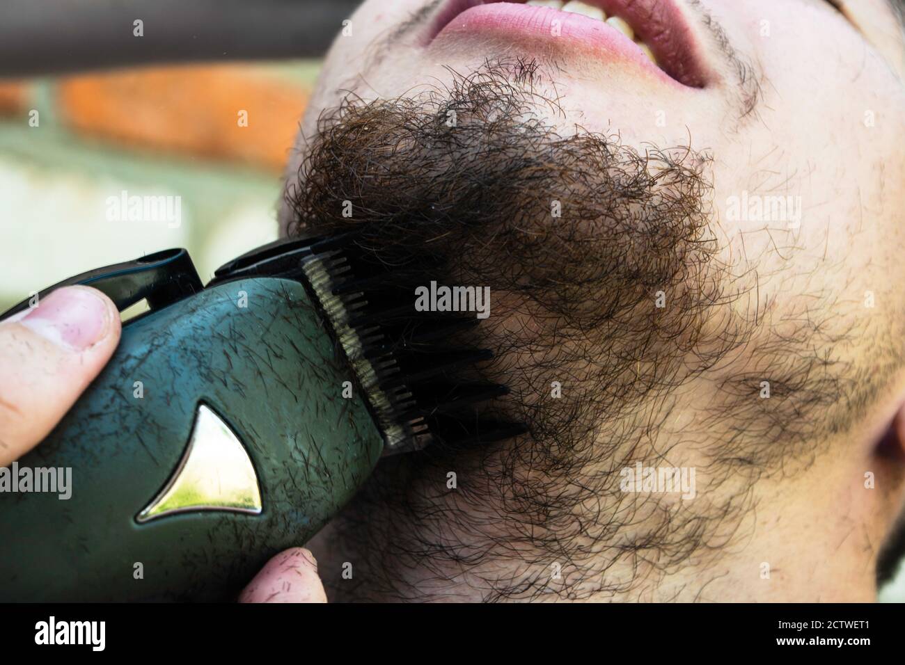 the barber cuts his beard to the guy with a shearing machine Stock ...