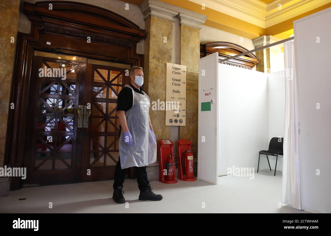 Staff member Gordon Sneddon walks between booths at a new walk-through ...