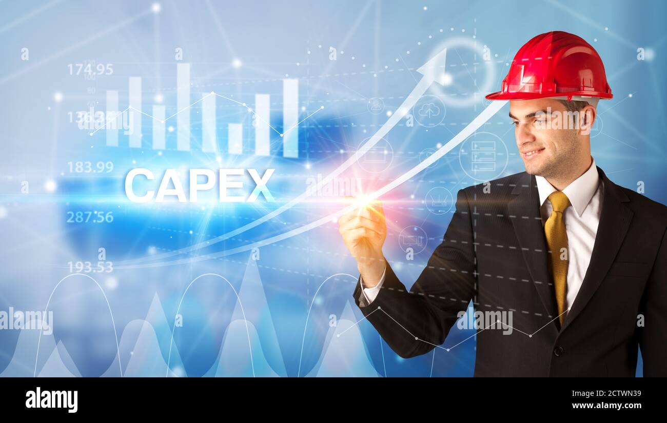 Young businessman with helmet drawing CAPEX inscription, modern ...