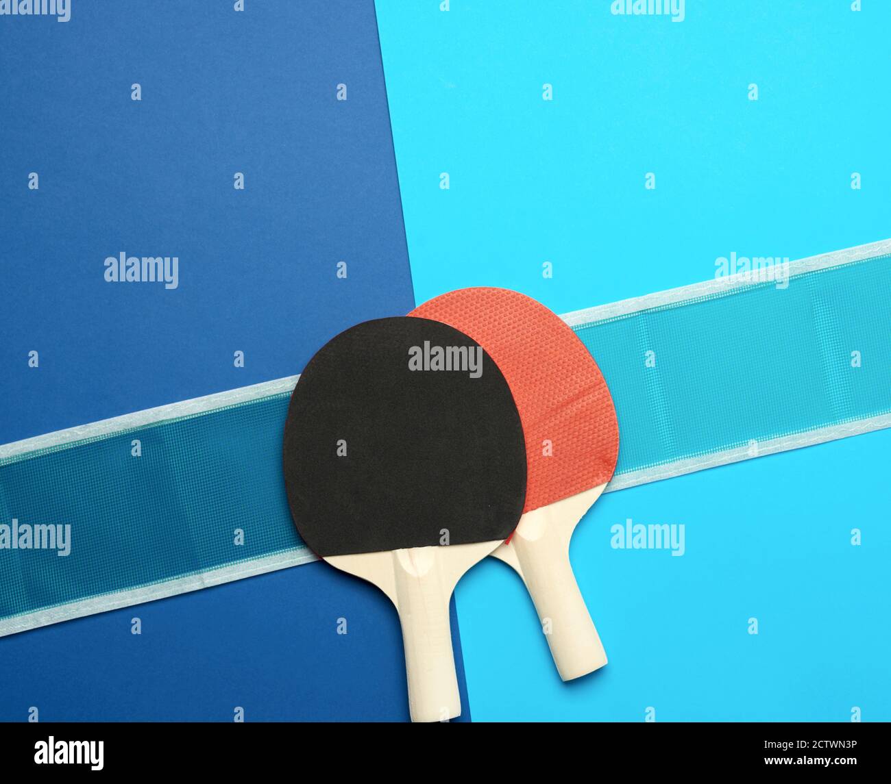 wooden rackets for playing table tennis and a net on a blue background ...