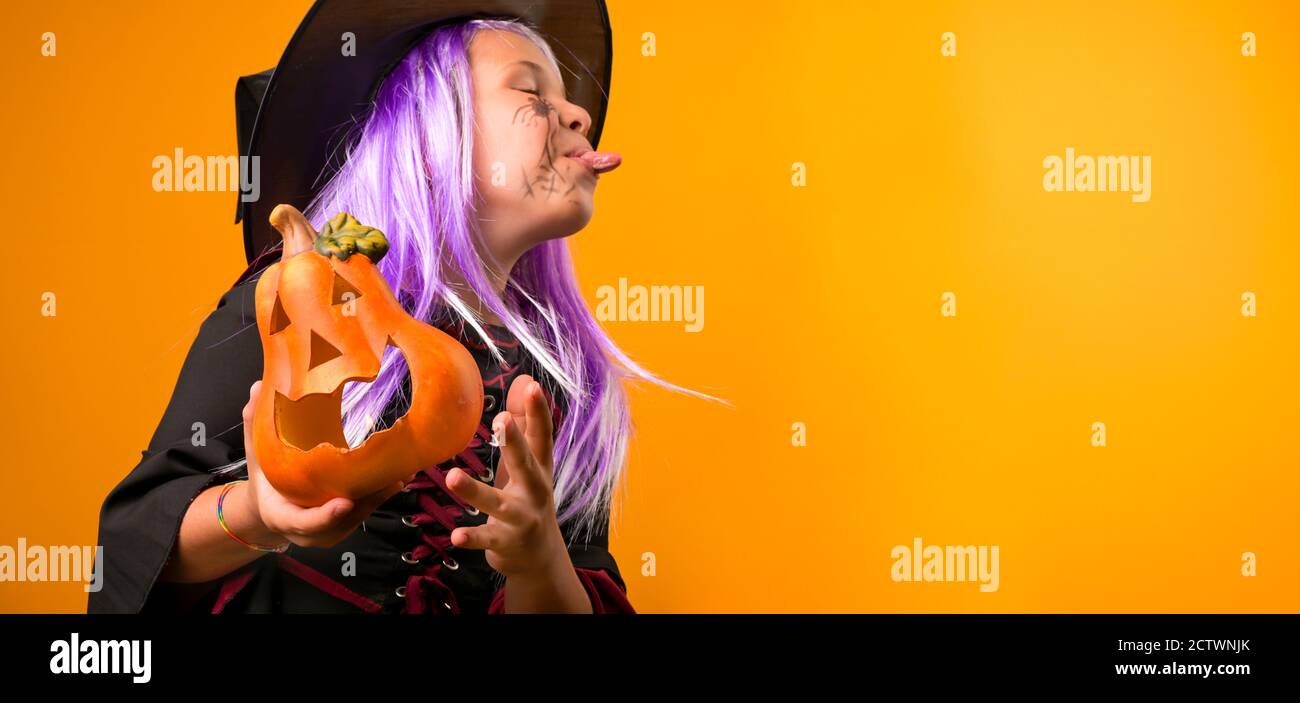 Enthusiastic little girl in a witch costume and heloin lanterns. Person ...