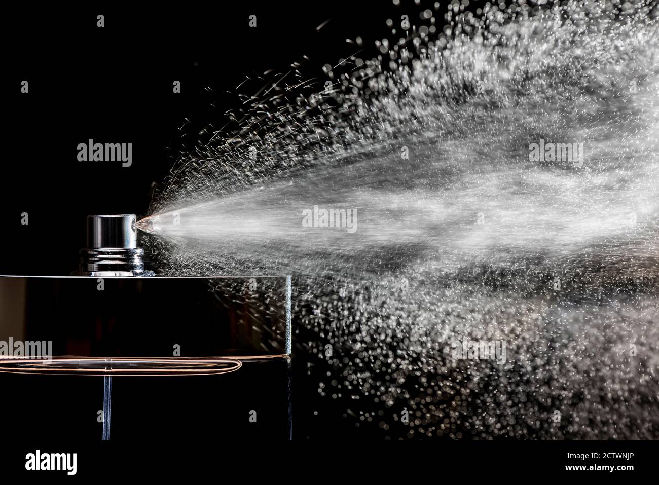 Perfume bottle close up with spray coming out Stock Photo - Alamy