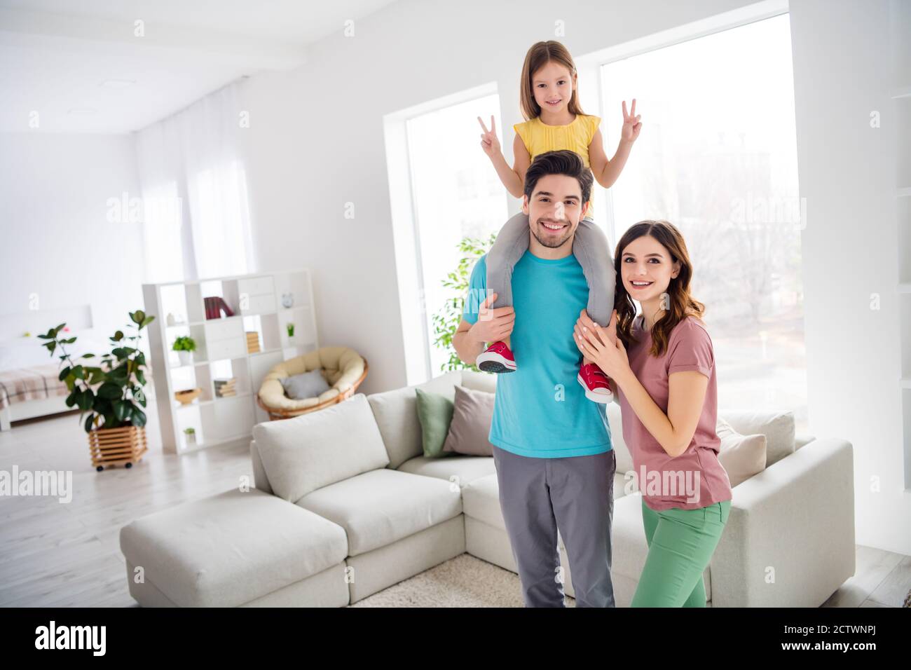 Photo of positive three people mom dad carry shoulders small girl kid ...