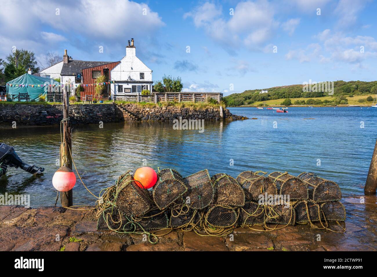 Lobster pots on jetty with Badachro Inn in background in former fishing ...