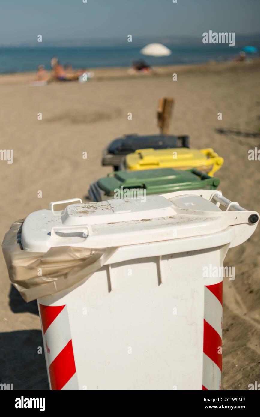 Color coded bins on beach to separate and recycle plastic, paper, metal ...
