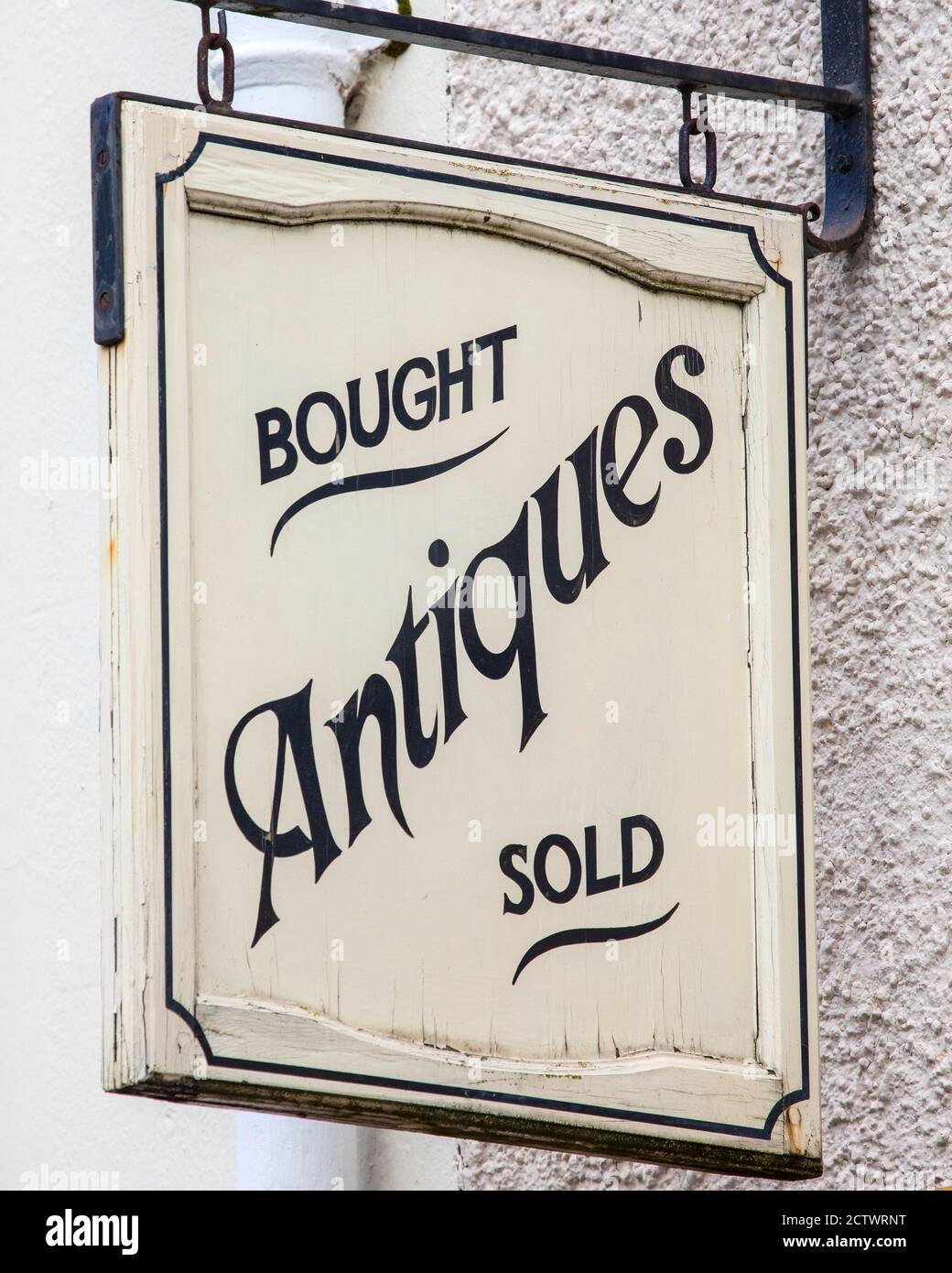 Close-up of an Antiques Bought and Sold sign hanging above an Antiques ...