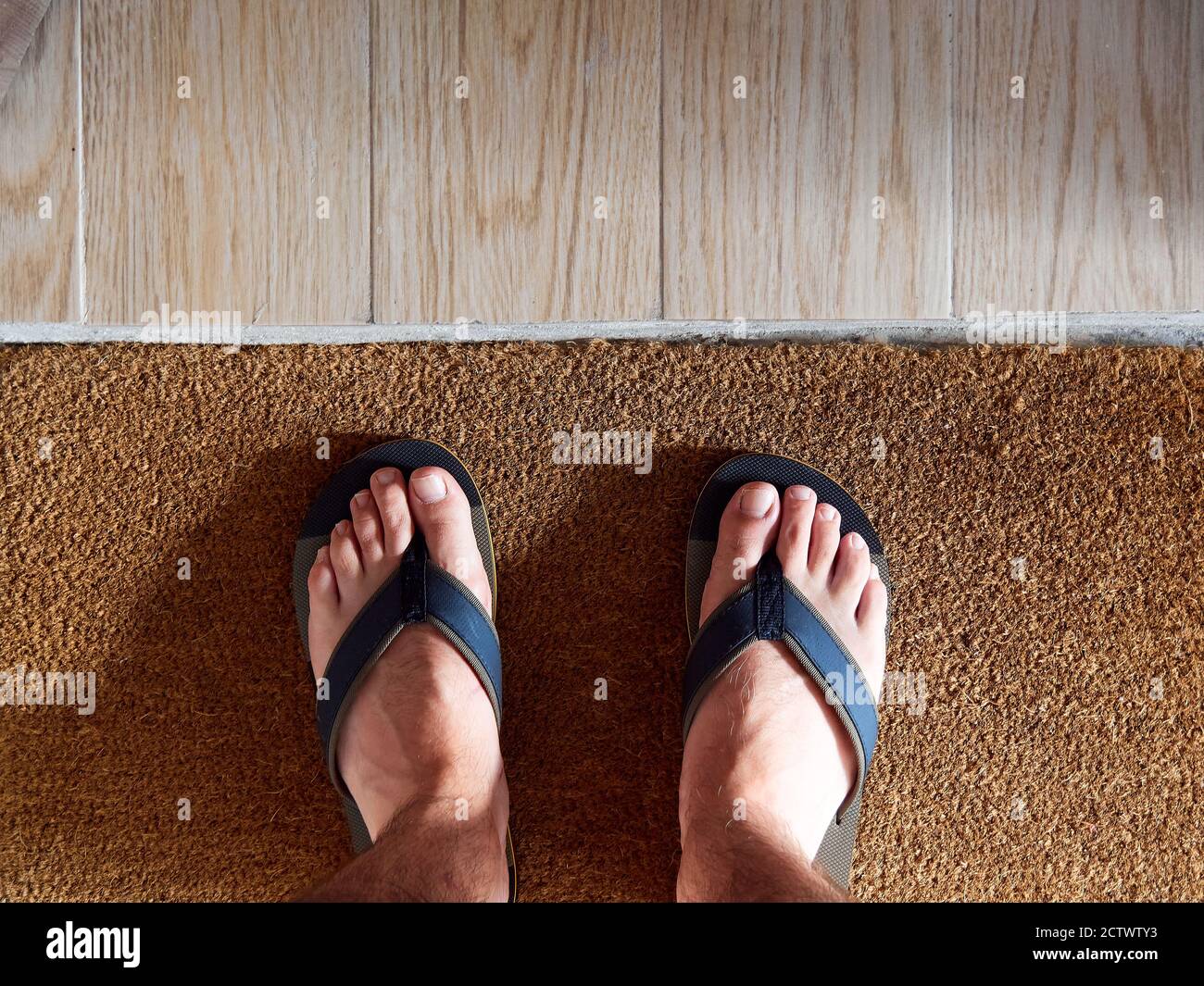 Top view of feet in black flip flops on the floor with carpet Stock ...