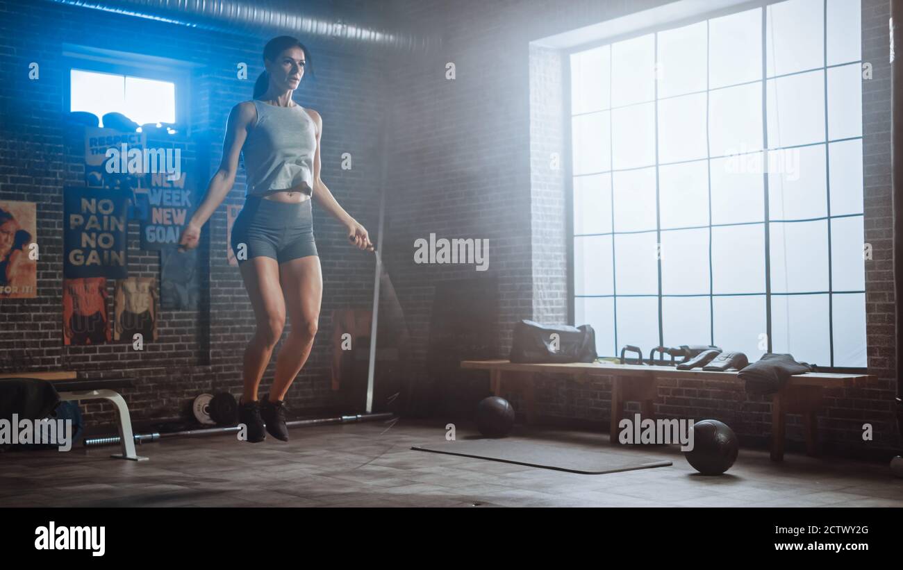 Strong Athletic Woman Exercises with Jumping Rope in a Loft Style ...