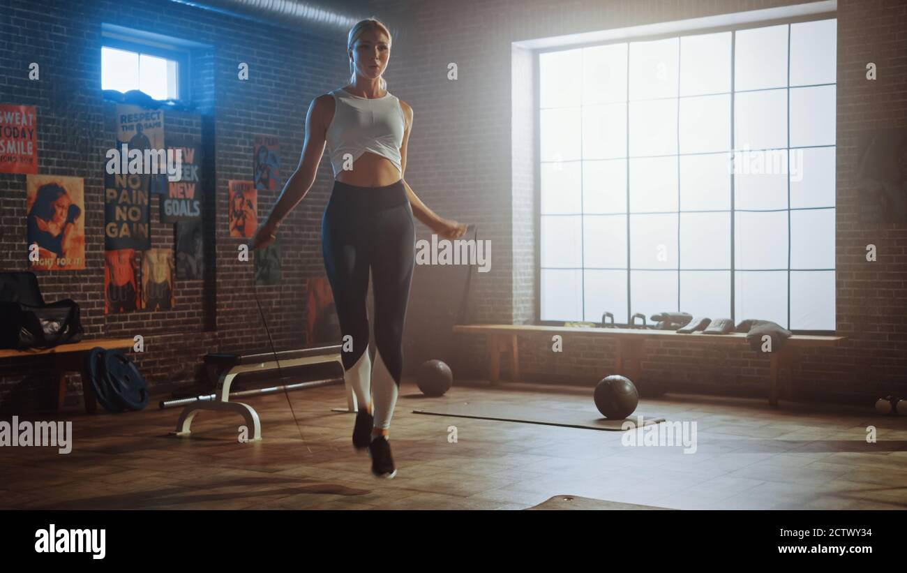 Fit Athletic Blond Woman Exercises with Jumping Rope in a Loft Style ...